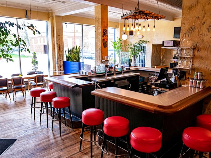 Those cherry-red bar stools aren't just seating—they're front-row tickets to watch mixologists work their magic in a space where mid-century meets modern day.