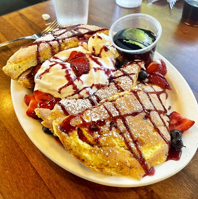 French toast that crosses into dessert territory without apology &ndash; berry-topped, syrup-drizzled, and absolutely worth the sugar rush.