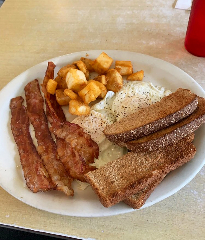 The breakfast trinity: perfectly cooked bacon, eggs with just the right amount of pepper, and toast that's actually been buttered all the way to the edges.