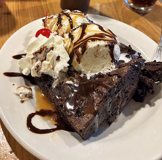 A brownie sundae that doesn't know the meaning of moderation. That hot fudge river flowing into ice cream valleys is pure dessert geography.