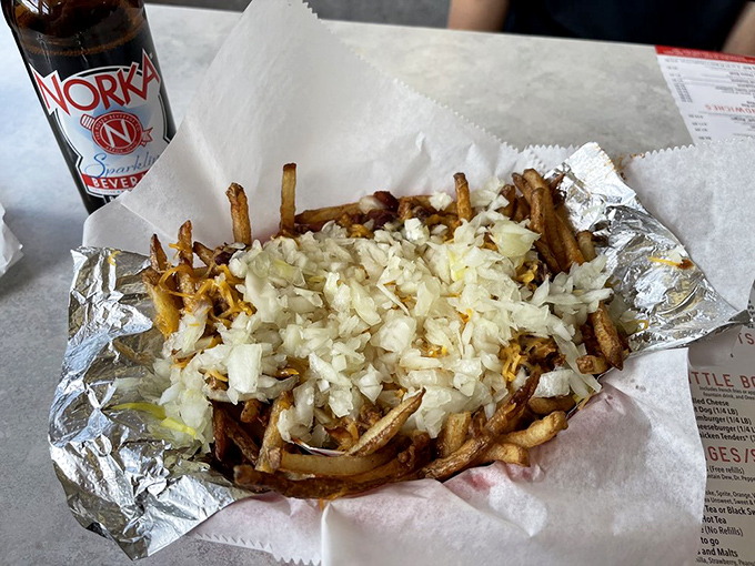 Fries living their best life under a blanket of diced onions &ndash; comfort food that understands the meaning of "more is more."