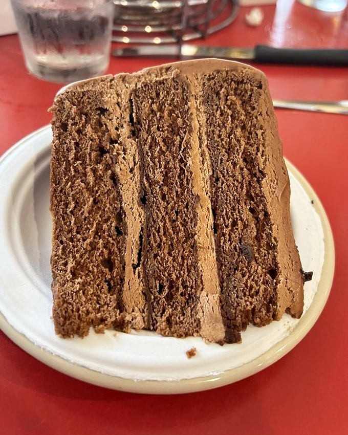 Chocolate cake so rich it probably has its own accountant—three layers of cocoa decadence that would make Willy Wonka jealous.