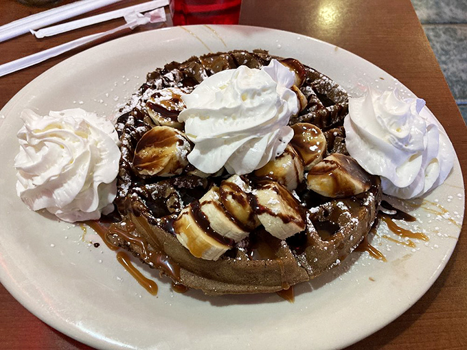 This waffle creation isn't just dessert; it's performance art with whipped cream. Somewhere, a dietitian just felt a disturbance in the force.