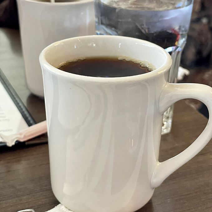 That classic white diner mug promises infinite refills and the gentle reminder that good conversations start with good coffee.