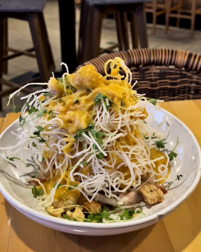 Crispy palabok noodles stacked higher than your weekend to-do list. A textural wonderland that's worth every delicious tangle.