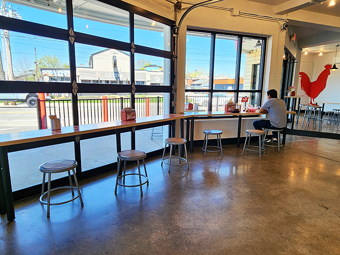 Window-side dining with a view of Columbus passing by. The red rooster silhouette stands guard, ensuring chicken standards remain uncompromised.