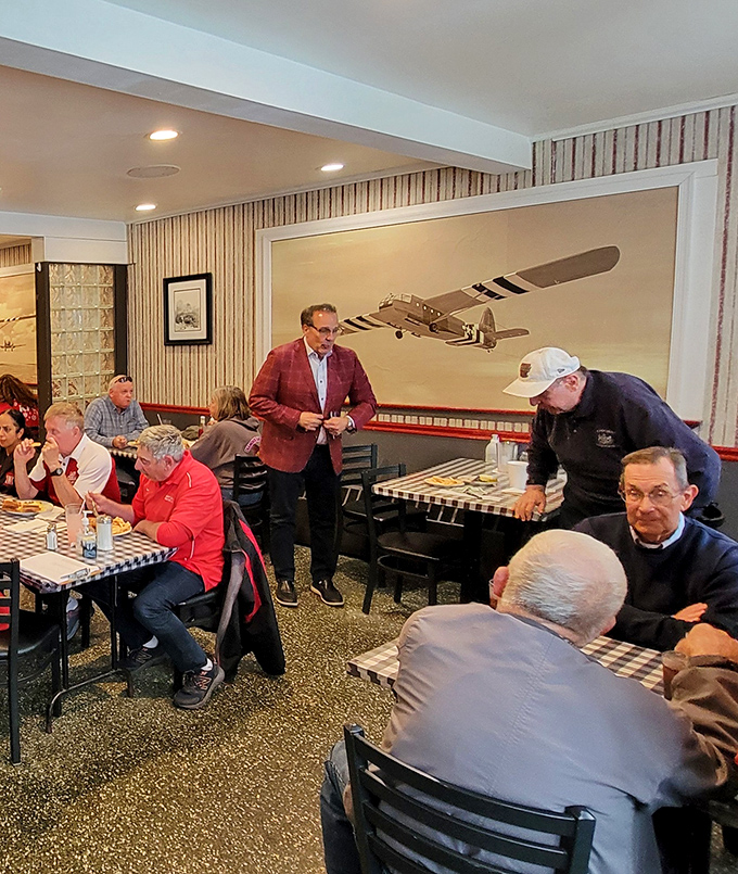 The aviation theme continues inside with vintage airplane art. Notice the locals deep in conversation&mdash;this isn't just a restaurant, it's a community hub. 