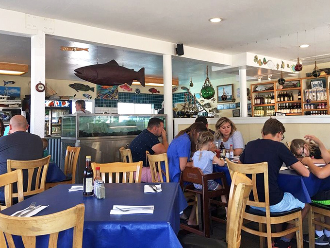 Families gathering around tables, sharing seafood and stories. The blue tablecloths match the ocean these delicacies came from&mdash;a thoughtful touch.