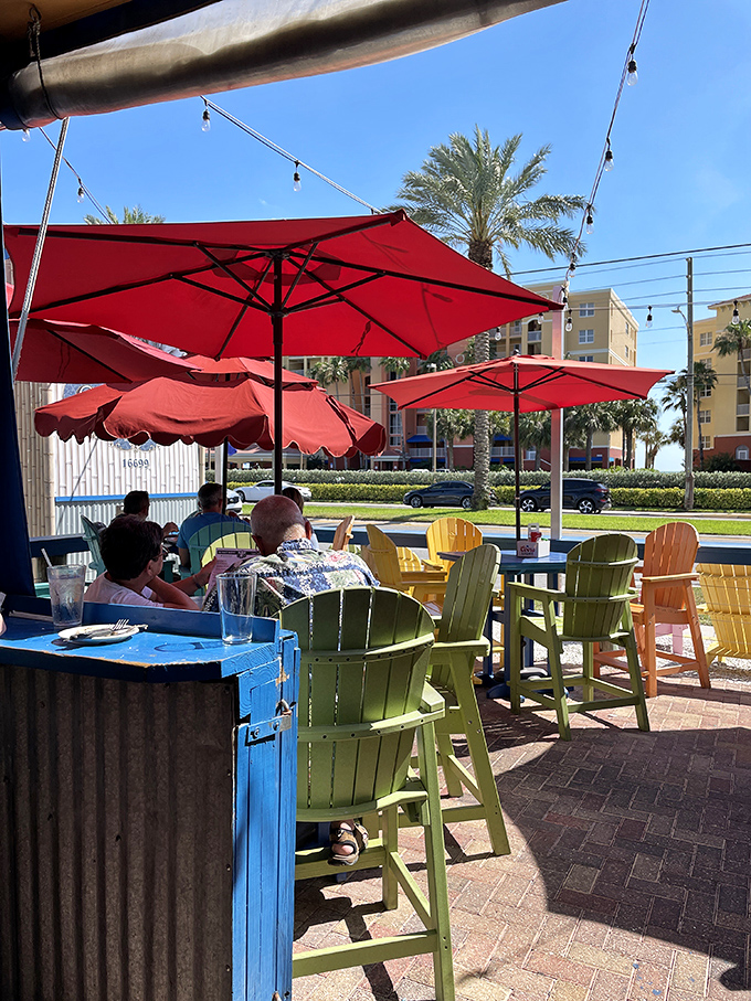 The outdoor seating area where salt air seasons every bite. Those colorful Adirondack chairs are practically begging you to linger over one more drink.
