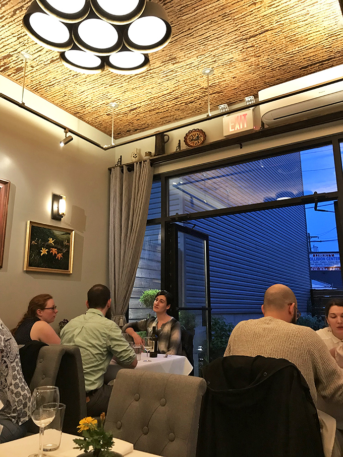 Evening conversations flow as freely as the wine at Elwood's intimate dining space. The textured ceiling catches the soft light while diners catch up on life's delicious moments.