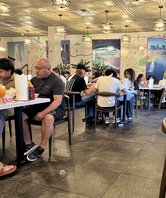 Diners lost in seafood bliss, surrounded by LA-themed wall art. The roll of paper towels on each table tells you everything about the gloriously messy experience ahead.