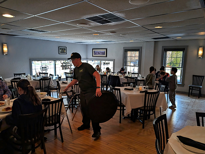 The bustling dining room captures that perfect Italian restaurant energy—part family gathering, part culinary theater, all delicious possibility.
