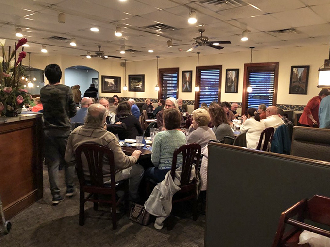 Happy diners enjoying the kind of meal that turns strangers into friends over shared plates.