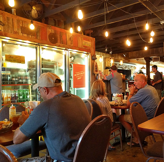 Where strangers become friends over shared barbecue appreciation. Edison bulbs casting that "everyone looks good in barbecue lighting" glow we all deserve.