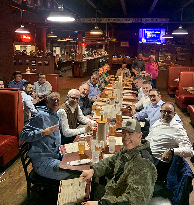 Where strangers become friends over shared BBQ appreciation. This long table of diners proves that great food creates community faster than any social network.