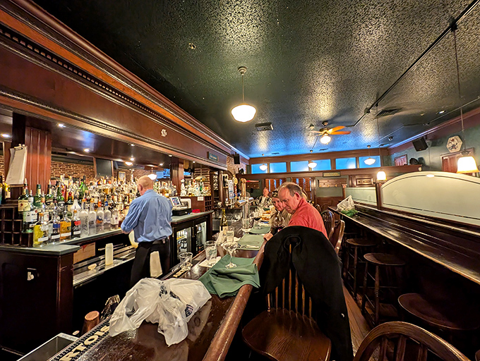 The bar area buzzes with energy as patrons gather for pre-dinner drinks or settle in for the full menu in more casual surroundings.