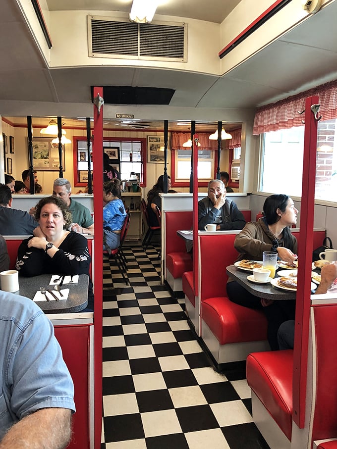 The classic diner aisle, where strangers become temporary neighbors. That black and white checkered floor has supported generations of hungry Pennsylvanians.