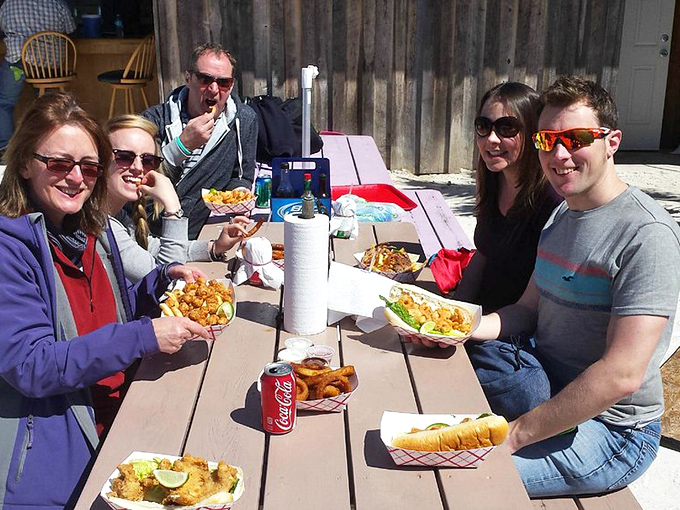 Happy diners enjoying the sunshine and seafood&mdash;the universal language of "we made the right choice stopping here" written all over their faces.