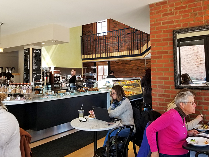 The two-story space creates a cathedral-like atmosphere for pastry worship, where patrons commune over coffee and carbs with appropriate reverence.
