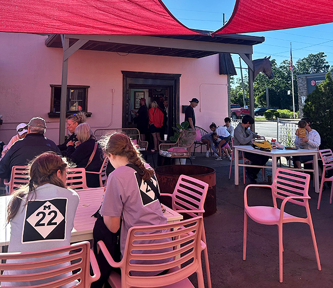 The outdoor patio: where burger enthusiasts gather under crimson shade sails. These pink chairs aren't just functional&mdash;they're the perfect pop of color for your Instagram feed and your afternoon.