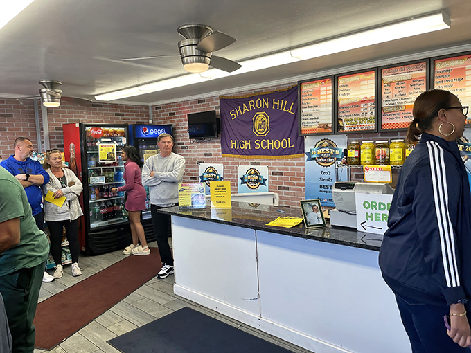 The line forms for a reason at Leo's counter. Local high school pride on display as hungry patrons await their turn at sandwich nirvana.