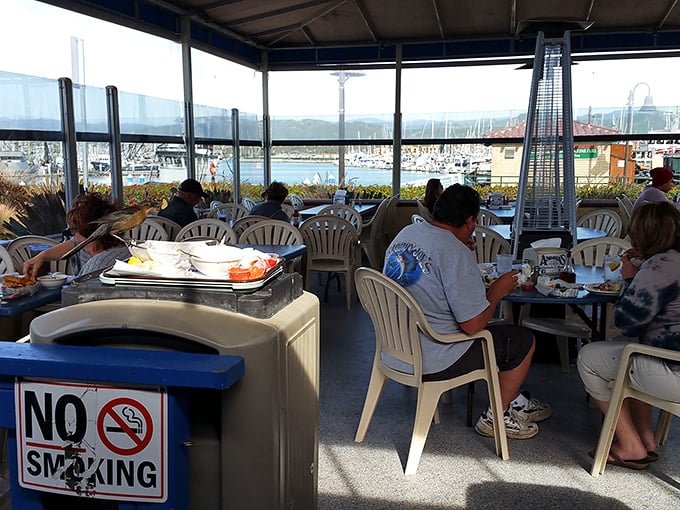 The covered patio offers harbor views that remind you exactly where your lunch was swimming before it became your lunch.