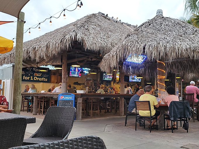 The tiki hut dining area offers the perfect Florida equation: cold drinks + sea breeze + zero chance of encountering your boss on vacation.