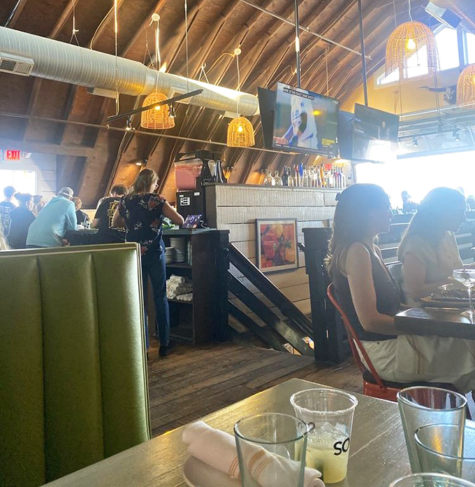 The vaulted ceiling and bustling bar create an atmosphere where strangers become friends over shared plates and tequila recommendations.