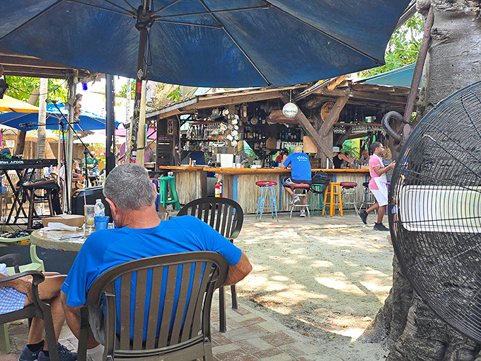 The outdoor bar area where weathered wood meets tropical vibes, creating the perfect spot to sip something cold while roosters provide entertainment.