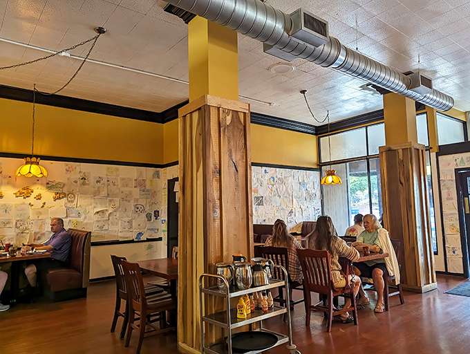 Yellow walls, exposed ductwork, and walls adorned with children's artwork create the perfect backdrop for morning conversations and coffee revelations.