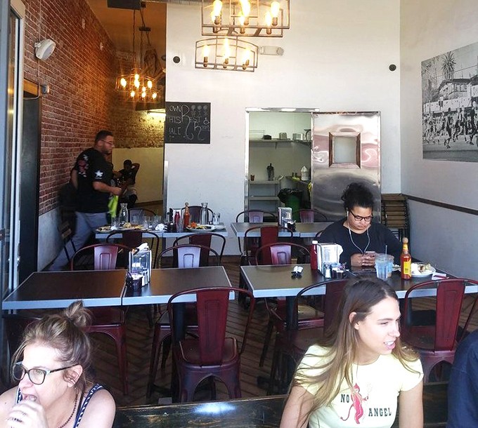 Industrial meets intimate in Millie's dining room. Exposed brick, metal chairs, and the promise of something delicious create the perfect breakfast sanctuary.