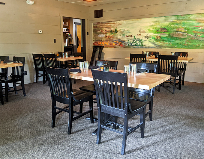 Simple wooden tables and chairs against cream walls with rustic artwork &ndash; no distractions from the main event on your plate.