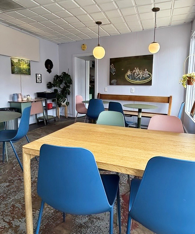 Sunlight streams through windows illuminating wooden tables and those signature colorful chairs. A space that feels both trendy and timeless.