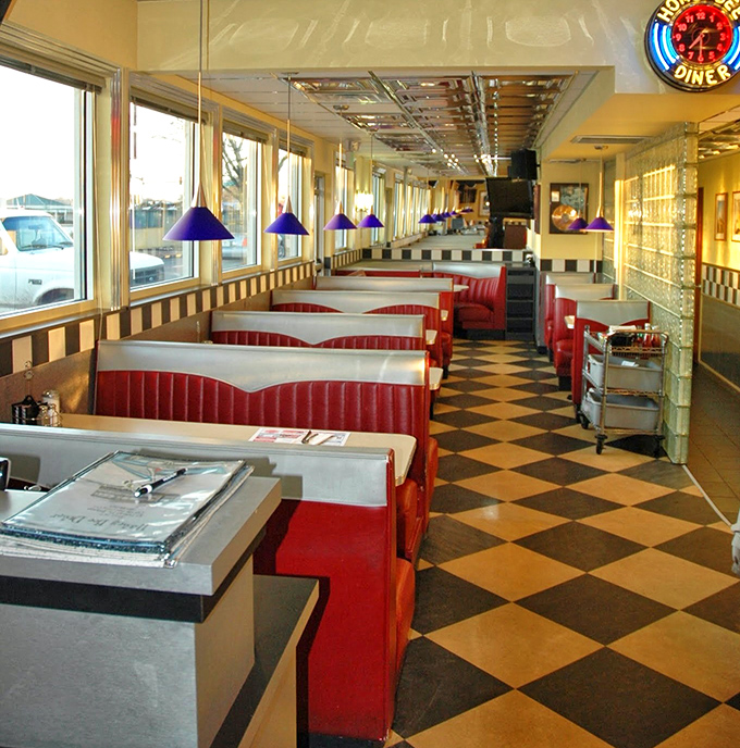 Classic diner geometry: red booths, checkered floors, and pendant lights creating the timeless equation for comfort and nostalgia.