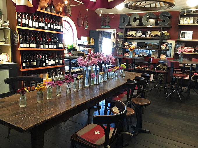 A communal table surrounded by wine bottles and rustic charm&mdash;the perfect setting for turning strangers into friends over shared meals.