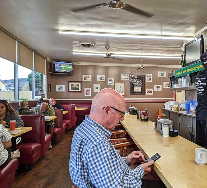 The dining room buzzes with authentic neighborhood energy where strangers become friends over shared meals.