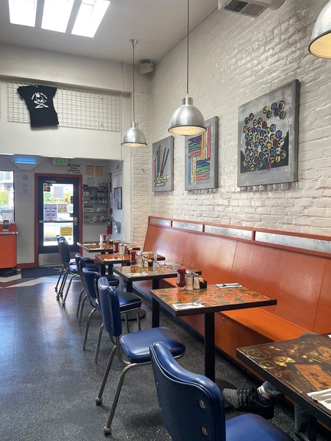 White brick walls, industrial lighting, and vibrant art create the perfect backdrop for morning conversations and coffee refills that never end.