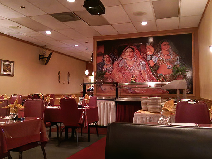 The large Bollywood mural watches over diners like a benevolent deity, blessing each table with good fortune and appetite.