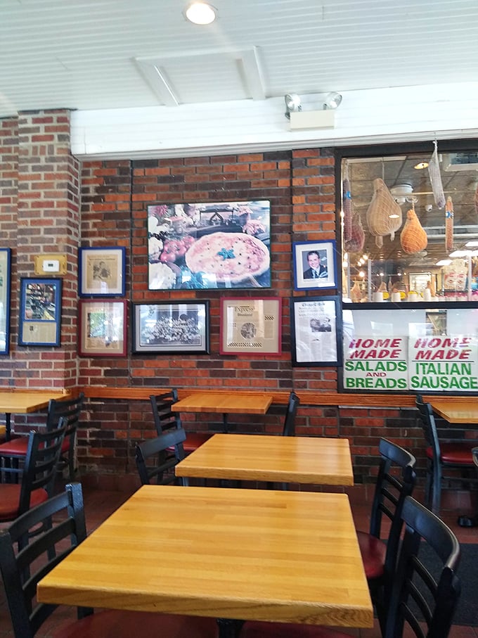 Brick walls lined with framed memories and wooden tables create the perfect backdrop for the main event&mdash;that pizza you're about to devour.