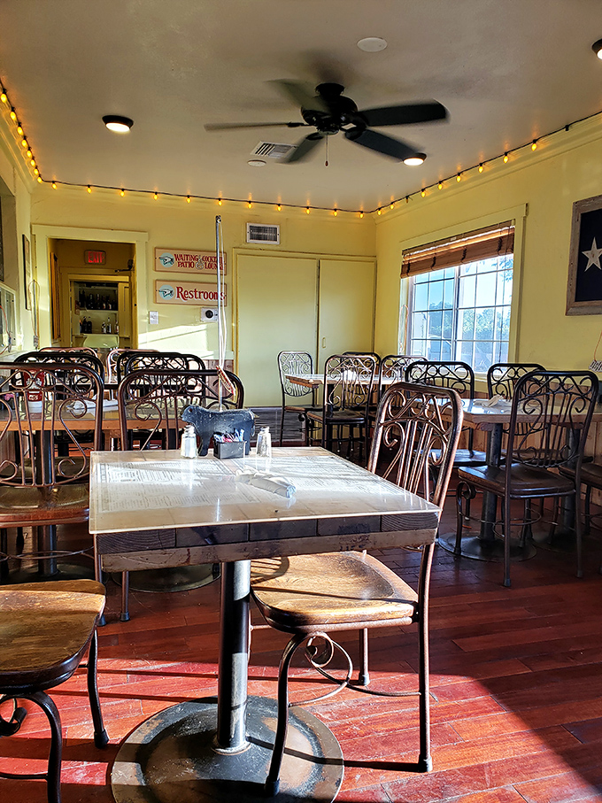 Yellow walls and string lights create the perfect backdrop for serious BBQ contemplation. Those wrought iron chairs have witnessed countless "first bite" moments of pure joy.