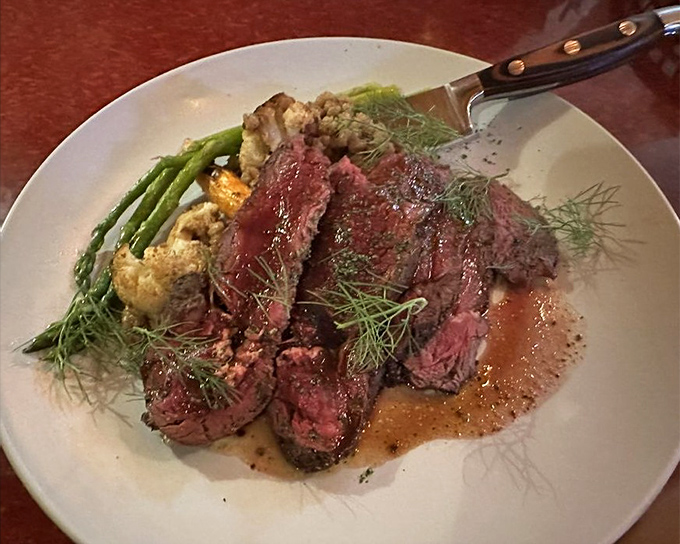 Elk loin sliced to showcase its ruby interior, proving that sometimes the best luxury is simplicity. The dill garnish adds a touch of forest freshness.