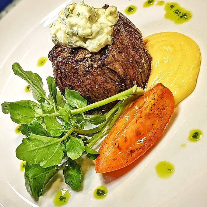 Even the steak gets the coastal treatment, topped with herb butter and served alongside a half lobster tail&mdash;surf and turf perfection on a pristine plate.