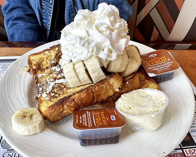 French toast that's dressed for success, topped with fresh bananas, whipped cream, and enough maple syrup to make a Canadian blush with pride.