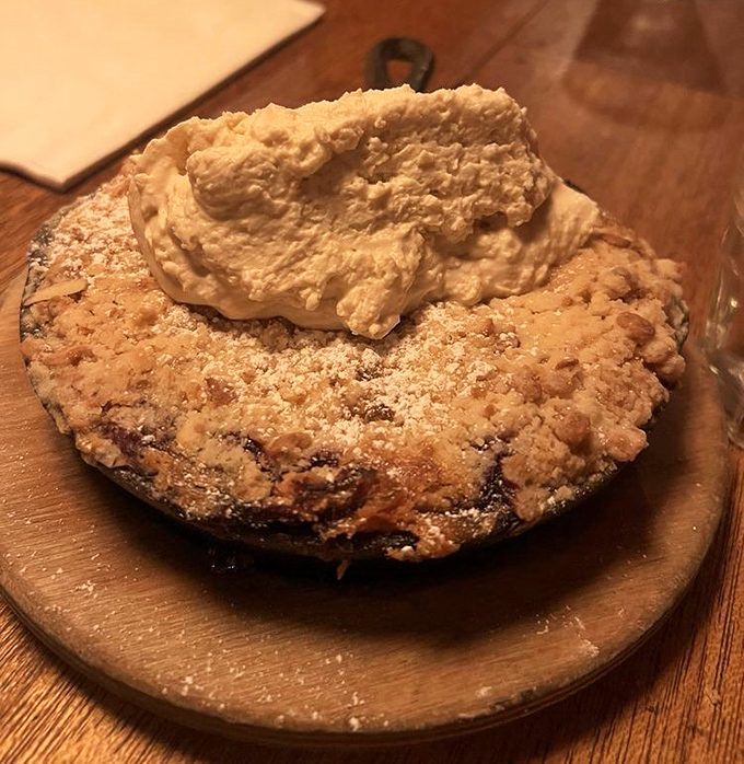 A fruit cobbler that makes you question why you ever bothered with fancy desserts &ndash; homestyle crumble topping and what appears to be fresh whipped cream.