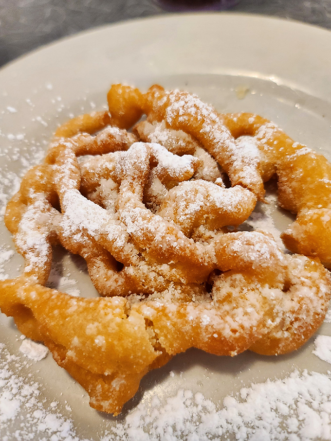 Funnel cake dusted with powdered sugar creates a carnival atmosphere right here at your cozy diner table.