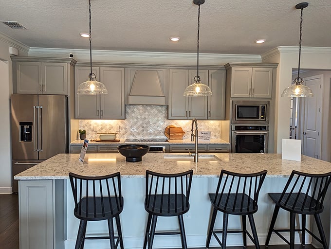 Kitchen island or entertainment venue? With pendant lighting this good and counter space this generous, it's definitely both.