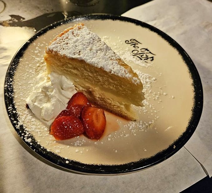 A slice of heaven dusted with powdered sugar and accompanied by strawberries&mdash;because every great steakhouse knows dessert isn't an afterthought.