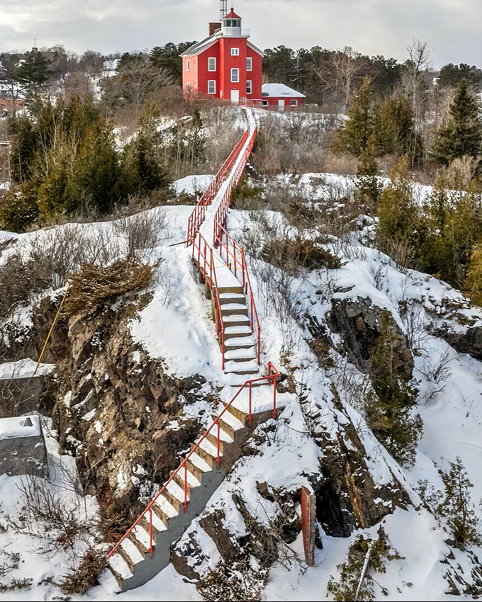 The red lighthouse perched dramatically above snow-covered cliffs seems to say, "Yes, the climb is worth it"&mdash;and the view proves it right.