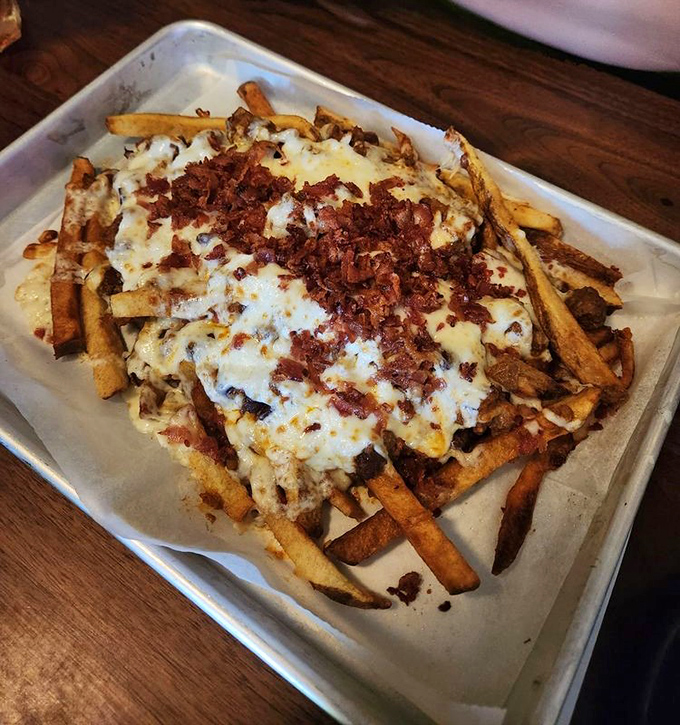 Loaded fries that require a game plan: crispy potatoes beneath a blanket of melted cheese and bacon bits. Diet starts tomorrow.