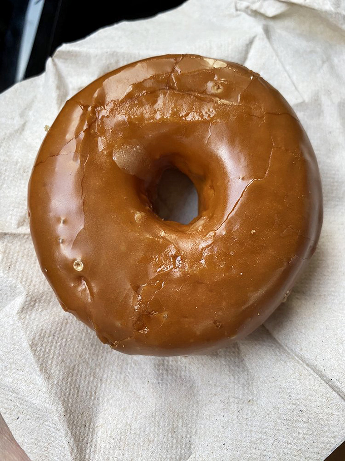 A perfectly executed maple glazed donut on humble paper&mdash;sometimes the simplest pleasures deliver the most profound satisfaction.